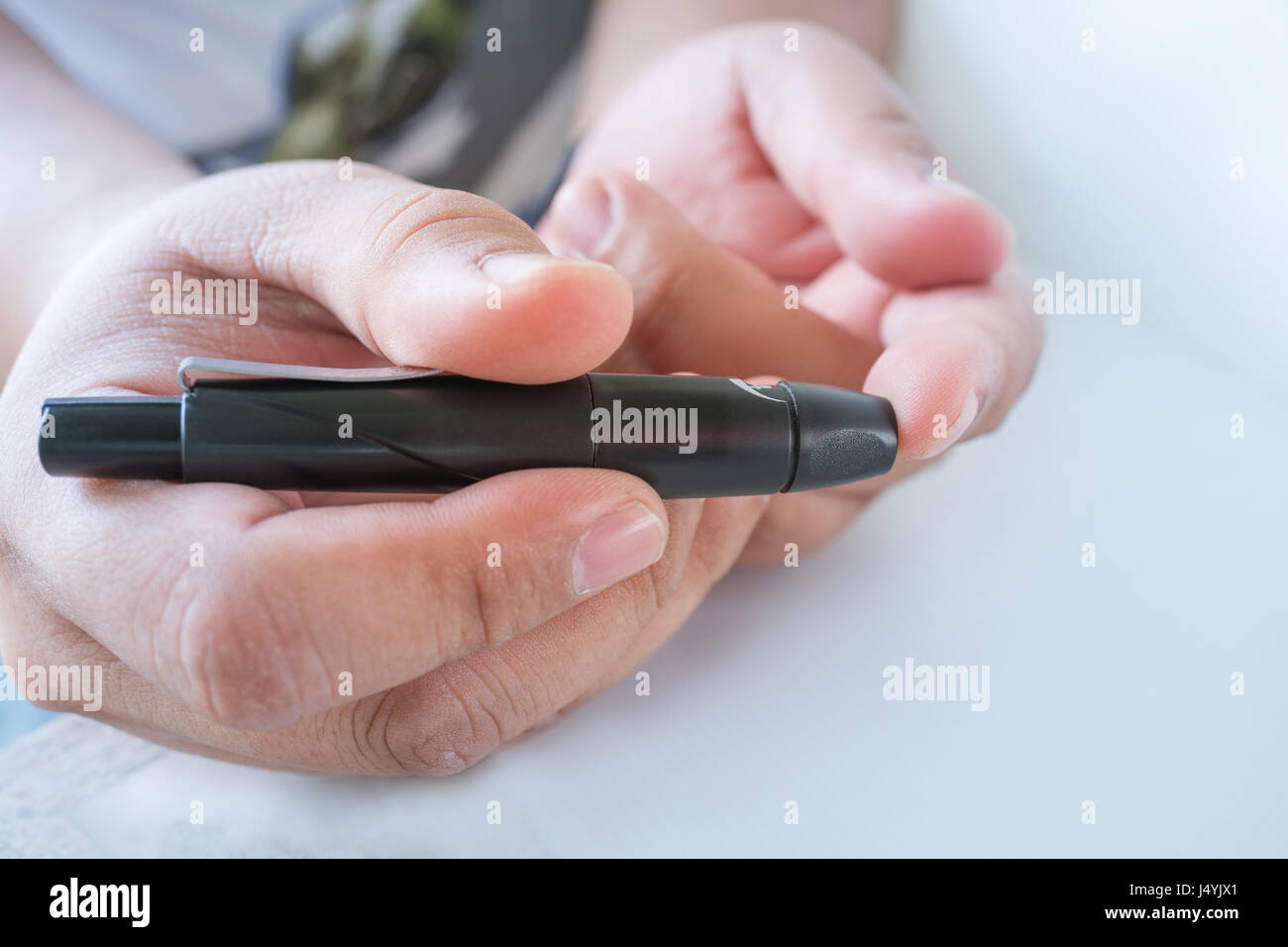 Close up of male finger patient pricking his finger to draw a drop for ...
