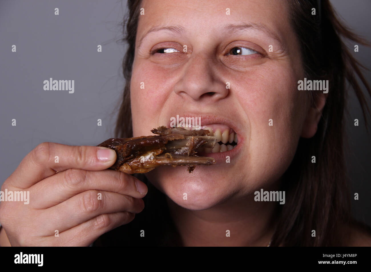 Woman eating meat Stock Photo - Alamy