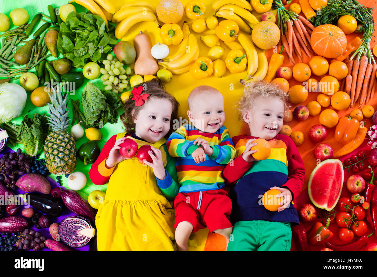 Boy, girl and baby with variety of fruit and vegetable. Colorful ...