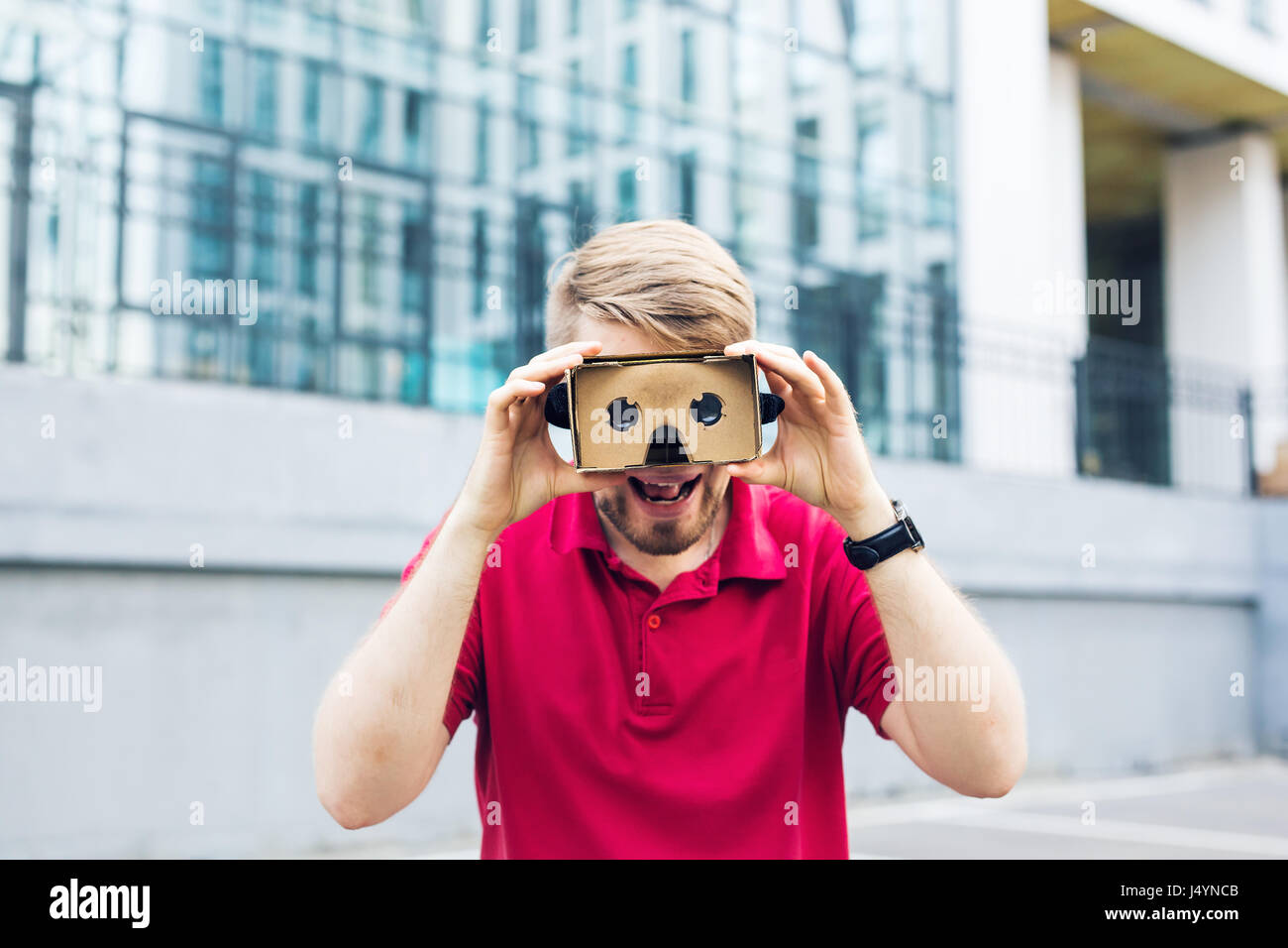 Funny man using cardboard virtual reality goggle outdoors Stock Photo ...