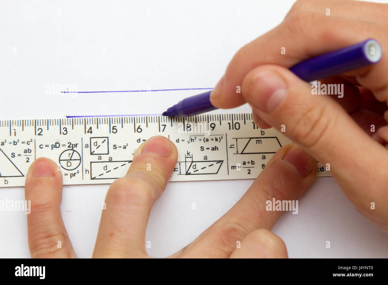 female's hand holding pencil and ruler drawing on blank notebook paper ...