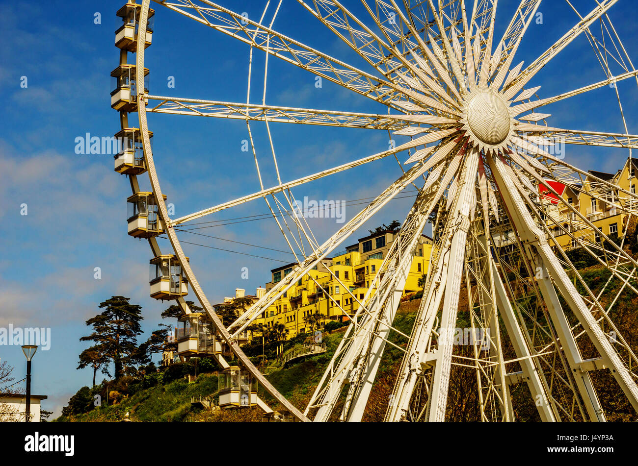 big wheel in the seaside village, in the background houses on the cliff ...