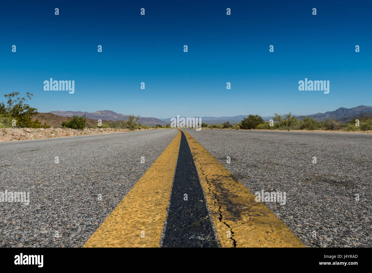 Low angle view of yellow strip on a Southern California desert road ...
