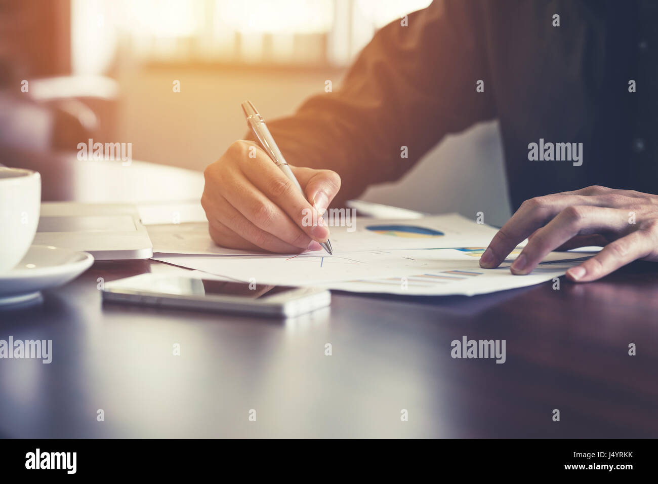 Young business man hand writing paper in the office with sunlight ...