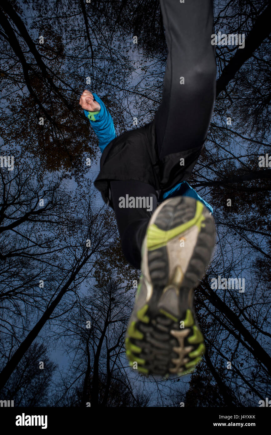 Low angle view of an adult man running in a forest trail in Jelenia ...