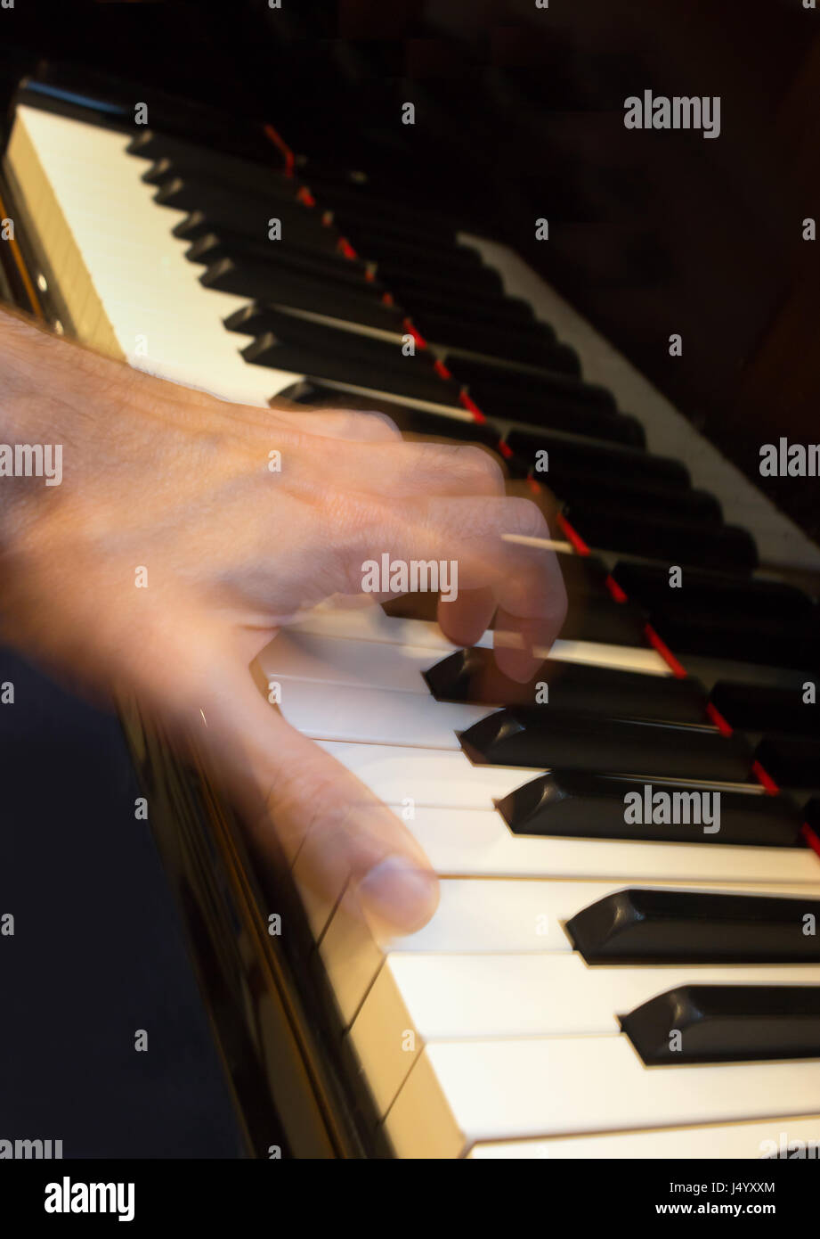 Pianist hand playing a chord on a keyboard, motion blur action ...