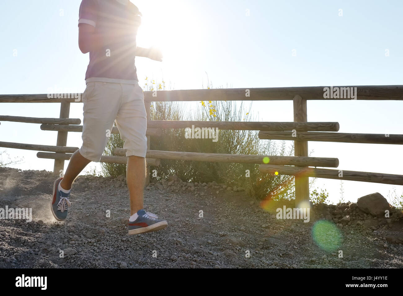 Man running on a mountain path at sunset Stock Photo - Alamy