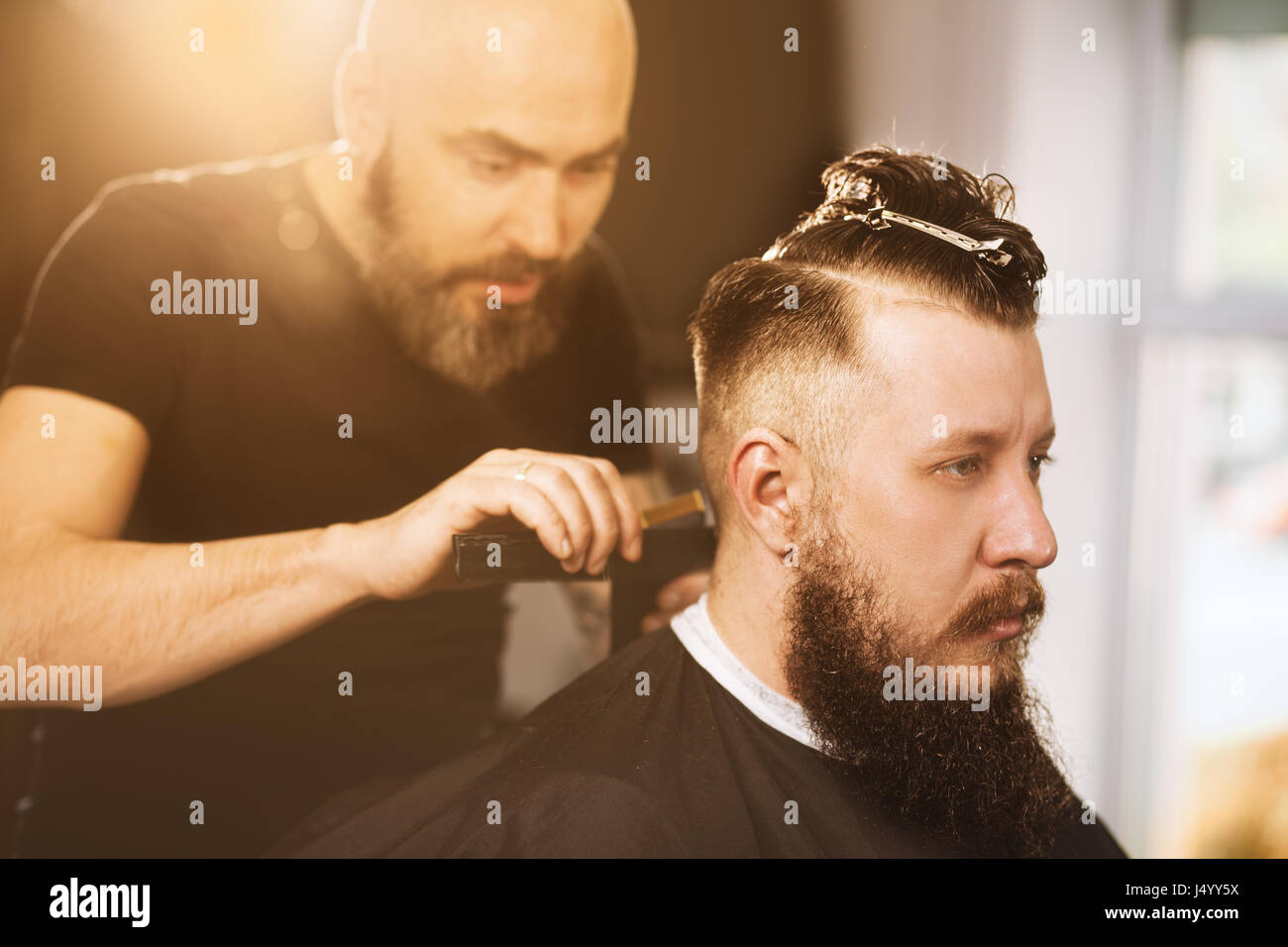 Professional barber in a barbershop doing a haircut Stock Photo - Alamy