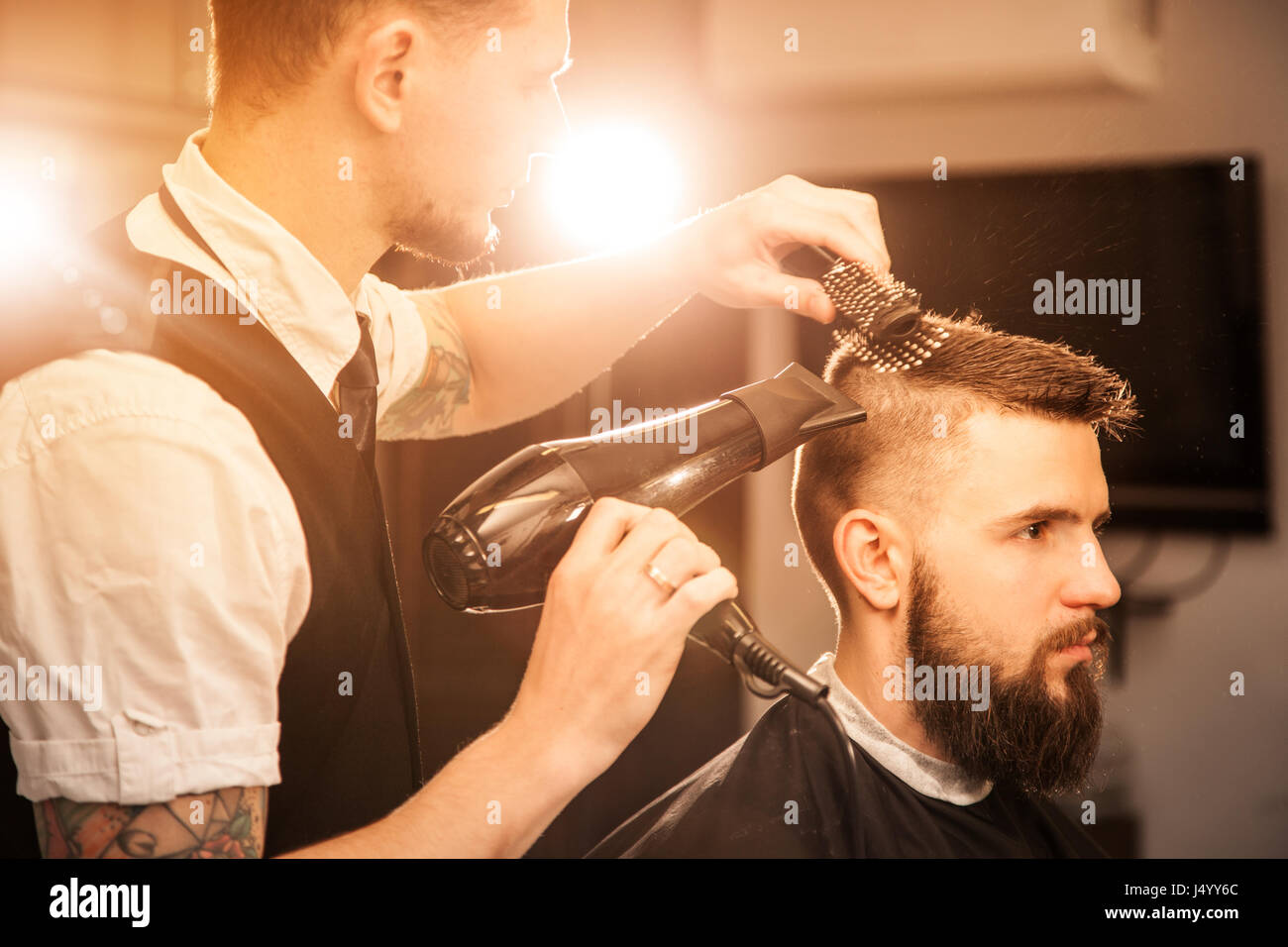 Professional barber in a barbershop doing a haircut Stock Photo - Alamy