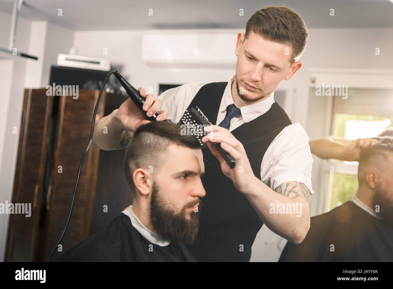 Professional barber in a barbershop doing a haircut Stock Photo - Alamy