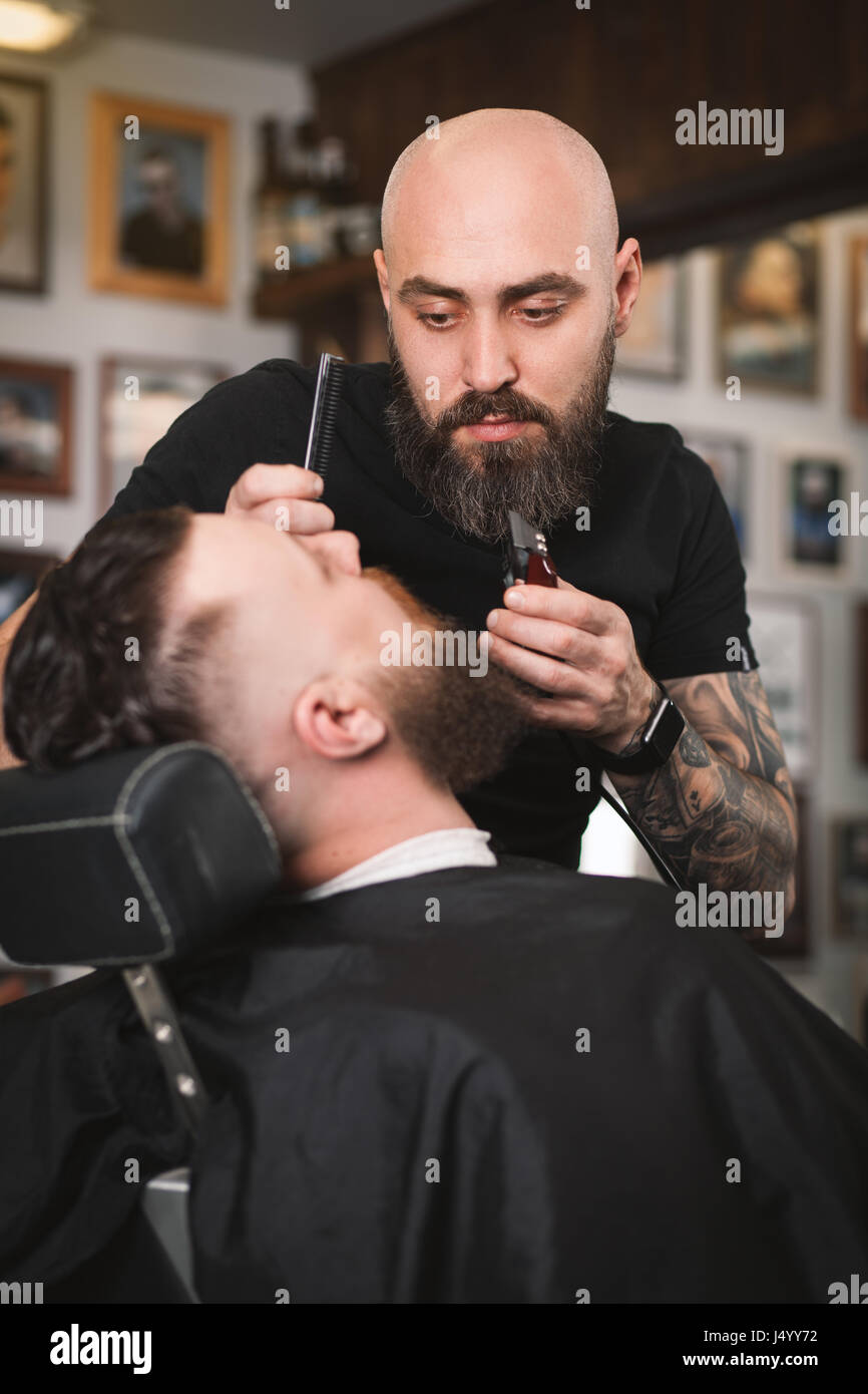 Professional barber in a barbershop doing a haircut Stock Photo - Alamy