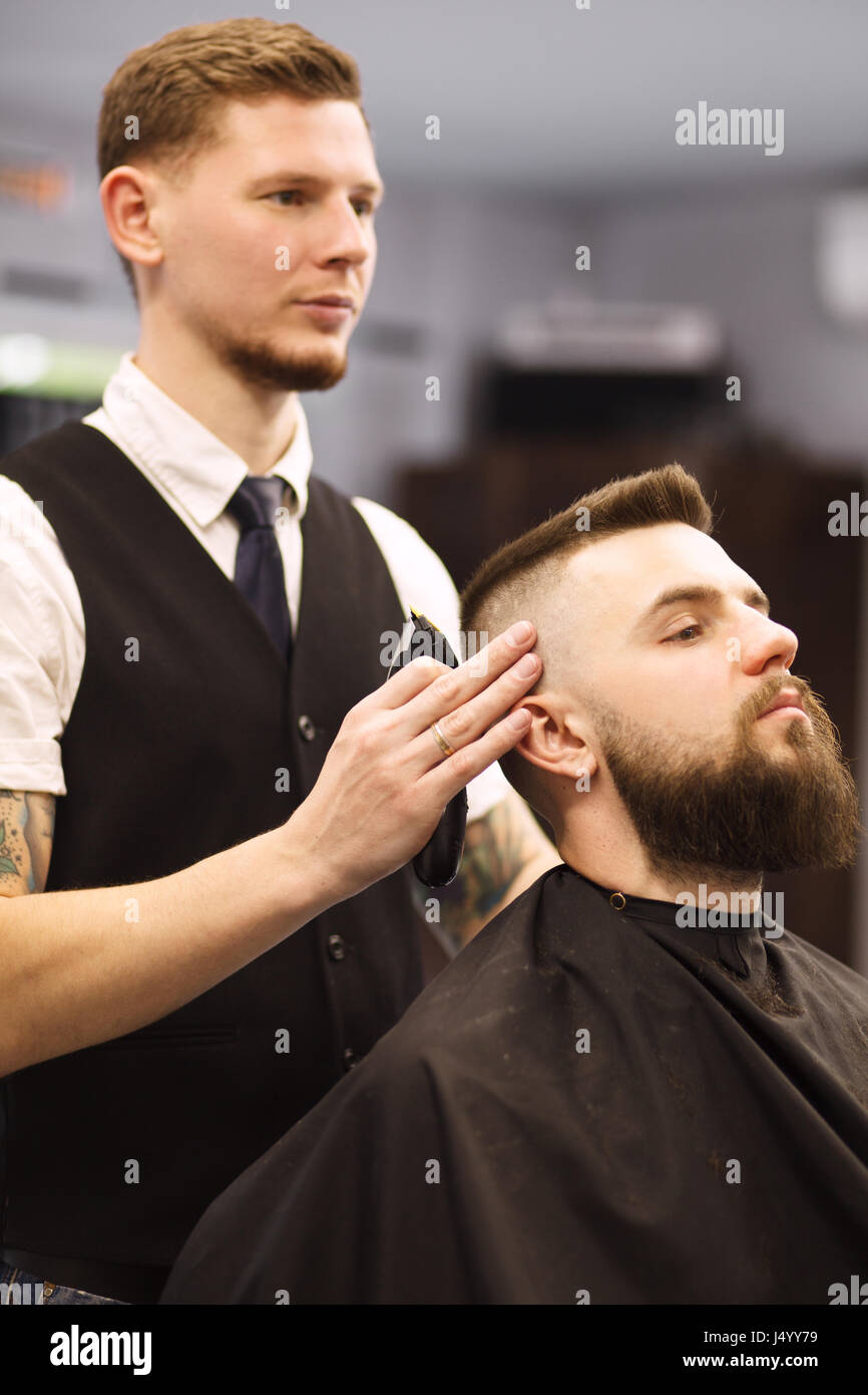 Professional barber in a barbershop doing a haircut Stock Photo - Alamy