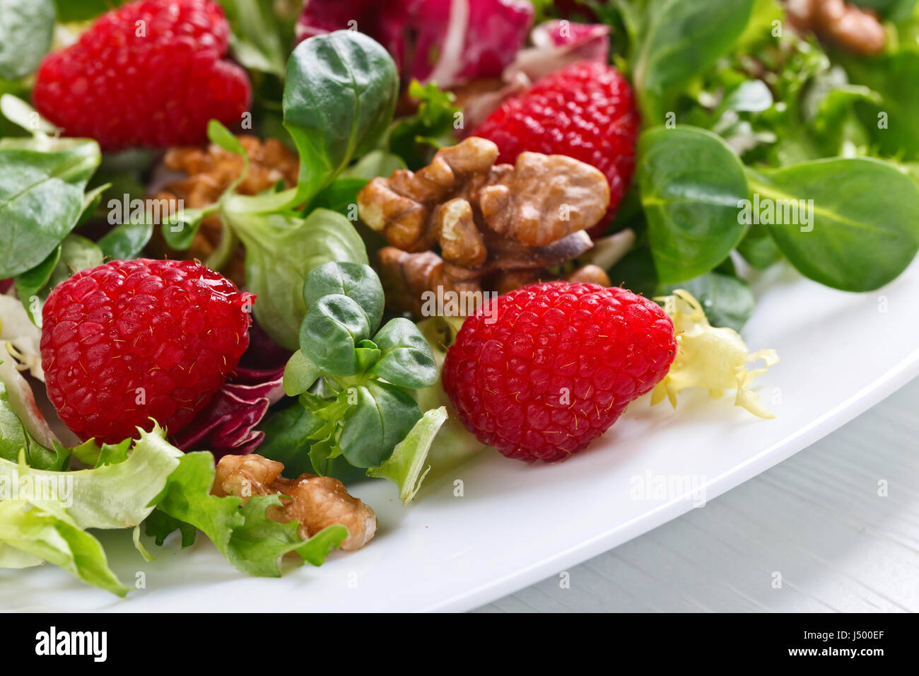 Green vegetarian salad with raspberry and nuts Stock Photo - Alamy