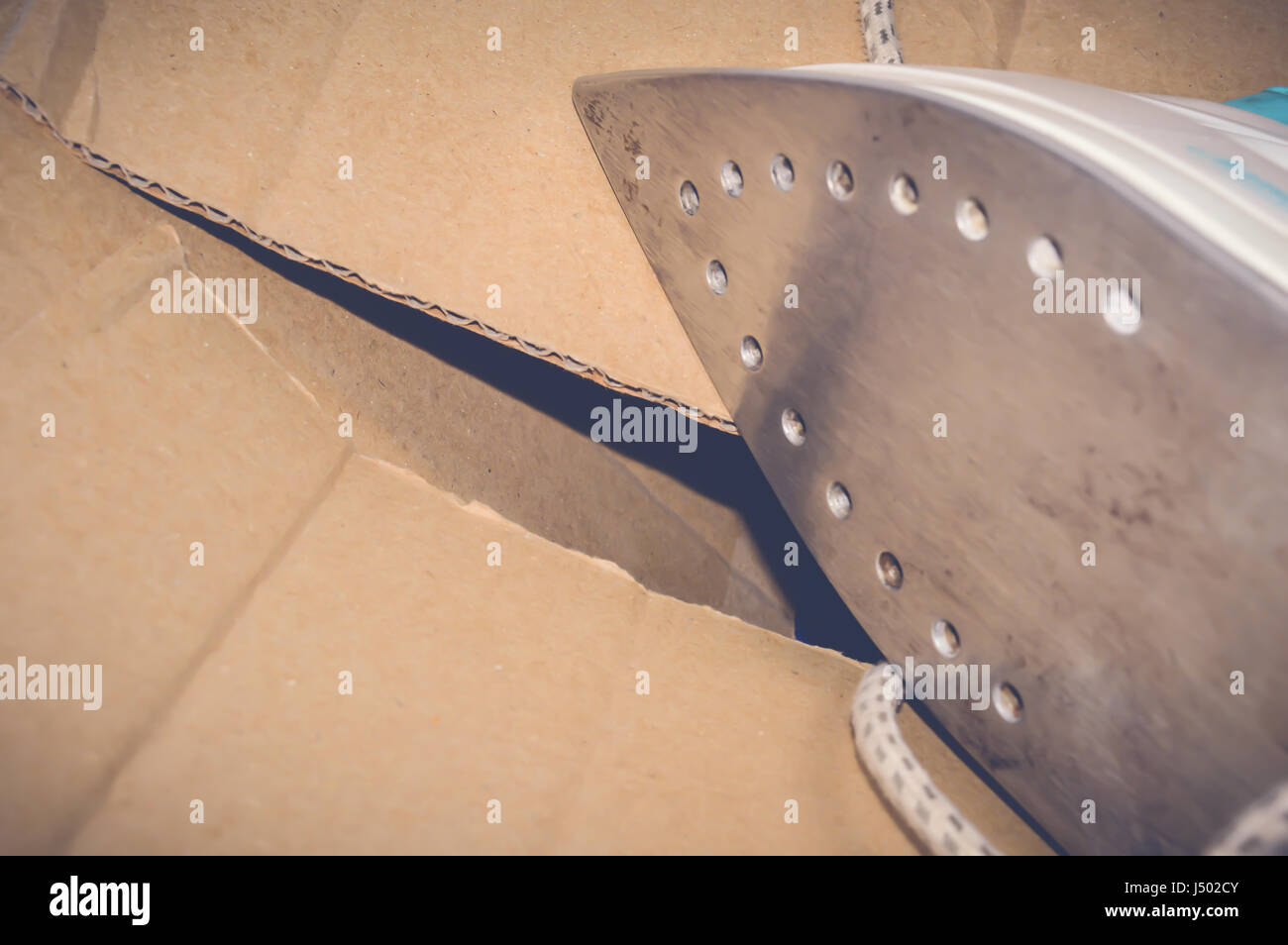 smoothing iron on brown background Stock Photo - Alamy