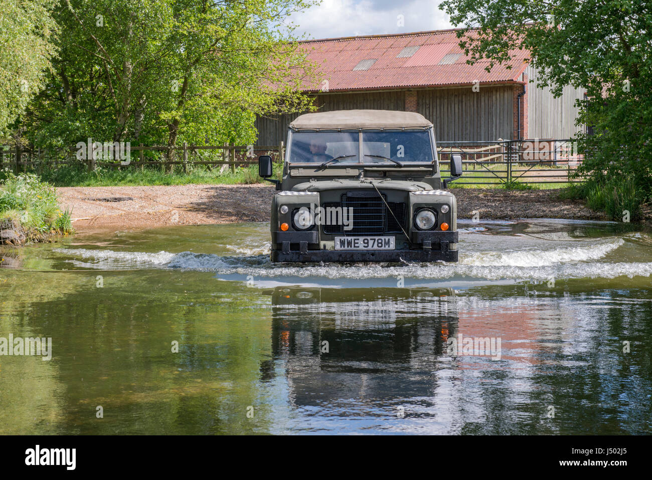 Model released image of a man driving a 1973 ex army Land Rover Series ...