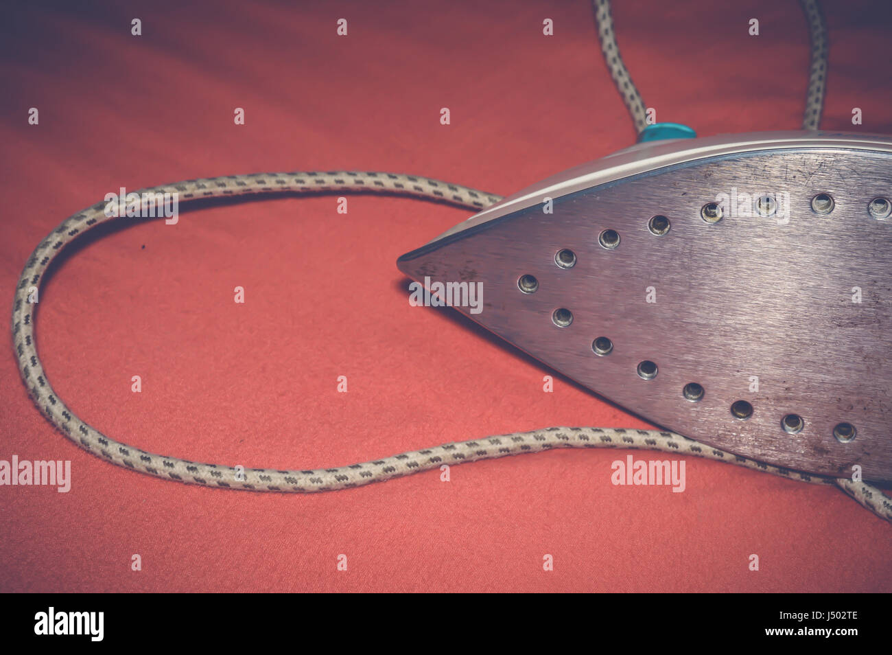 smoothing iron on red background Stock Photo - Alamy