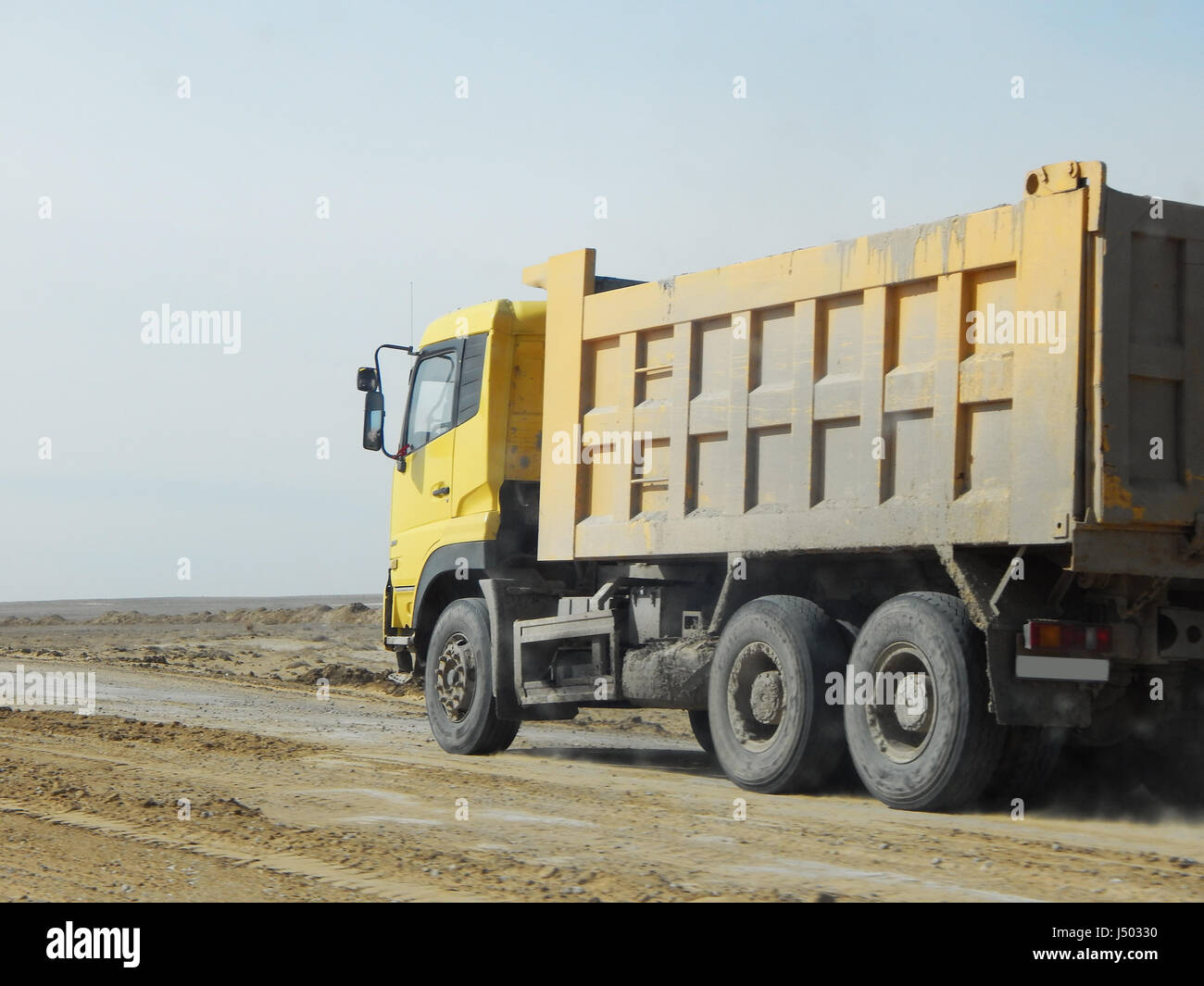 loaded truck is driving along a dirt road Stock Photo - Alamy