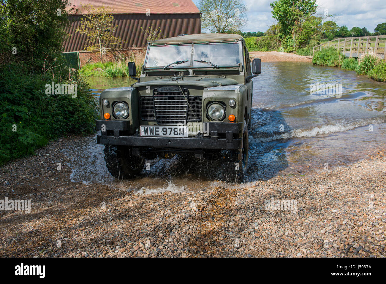Model released image of a man driving a 1973 ex army Land Rover Series ...