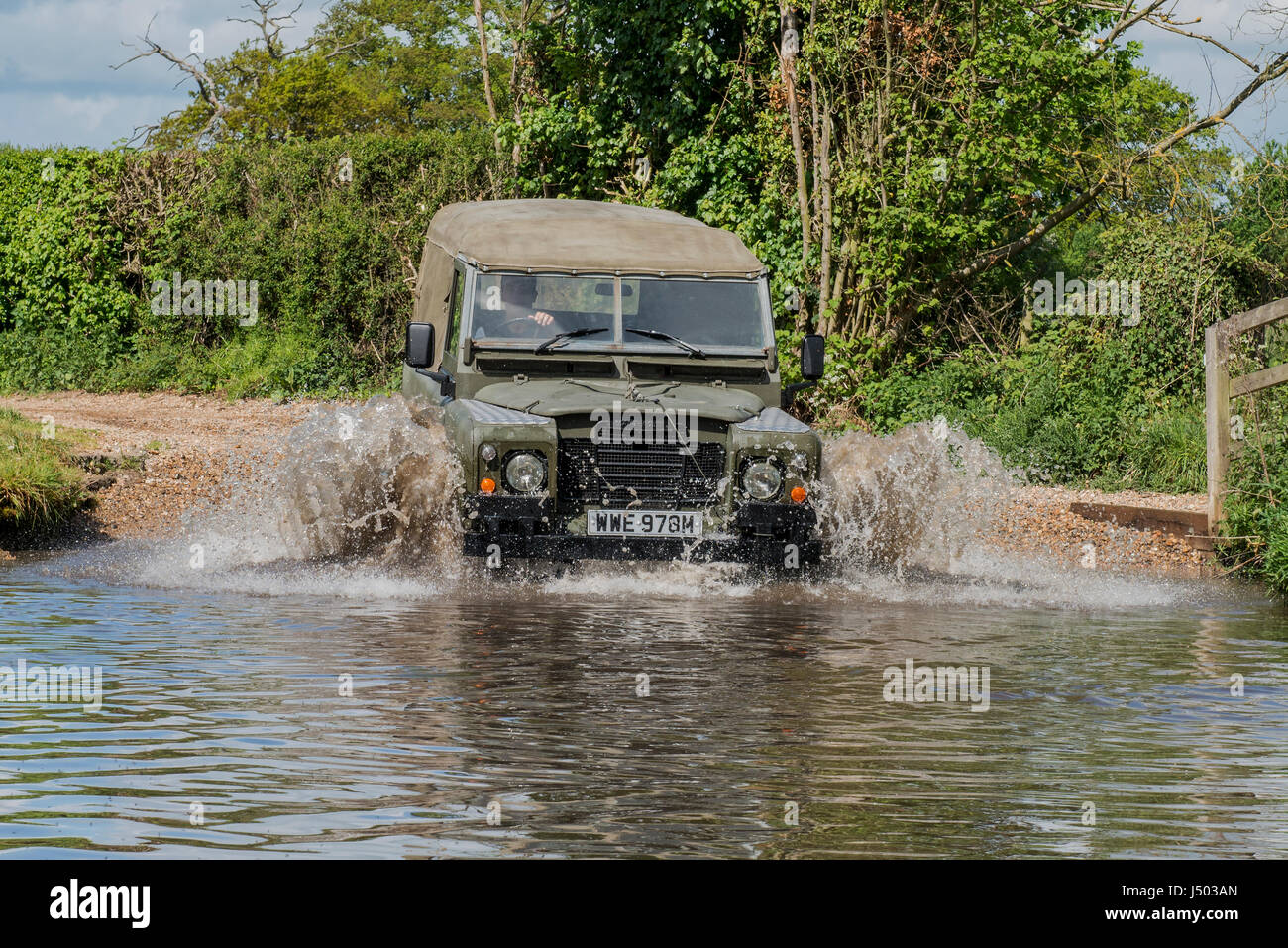 Model released image of a man driving a 1973 ex army Land Rover Series ...