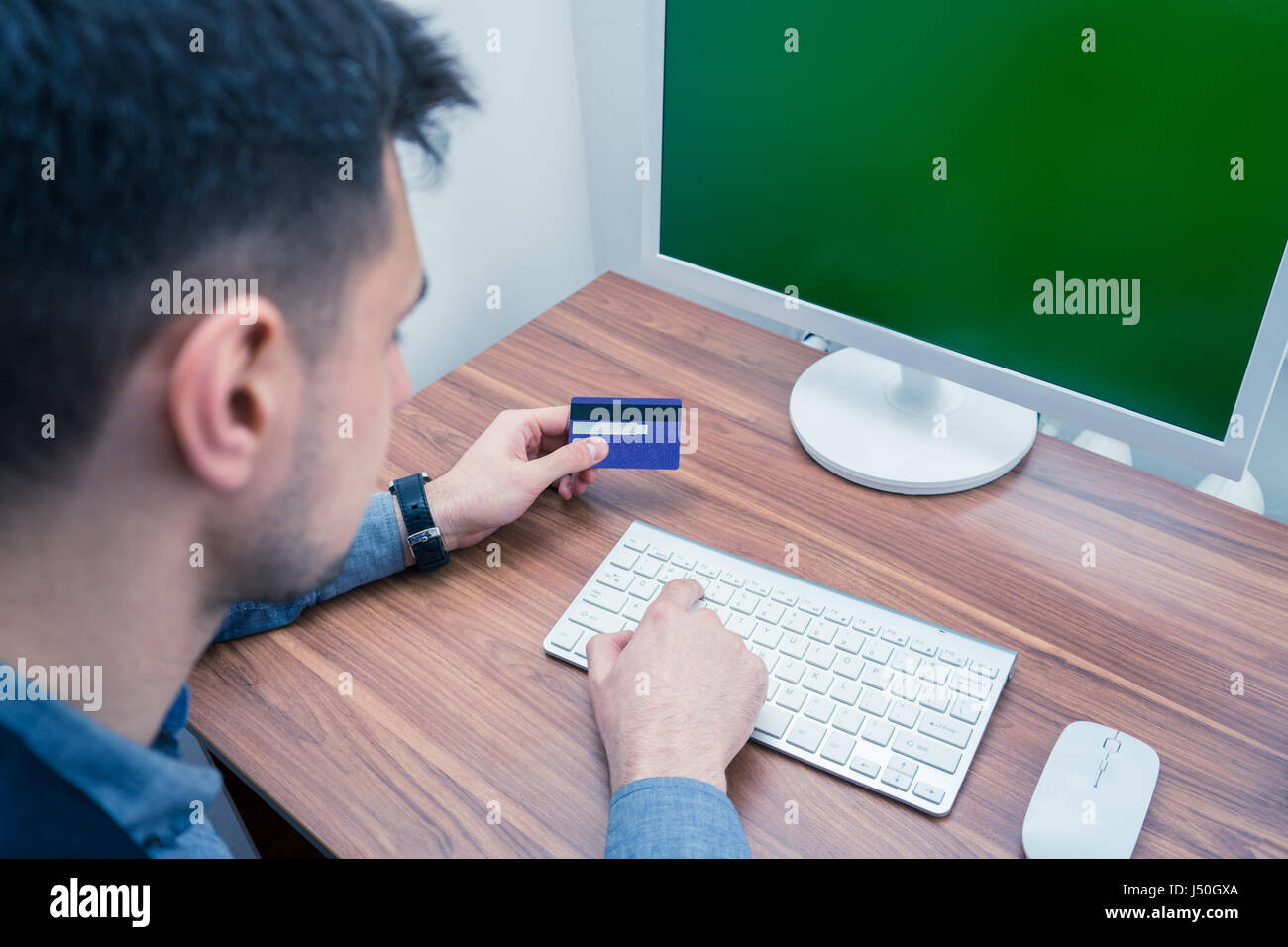Office worker holding credit card and making online purchase Stock ...