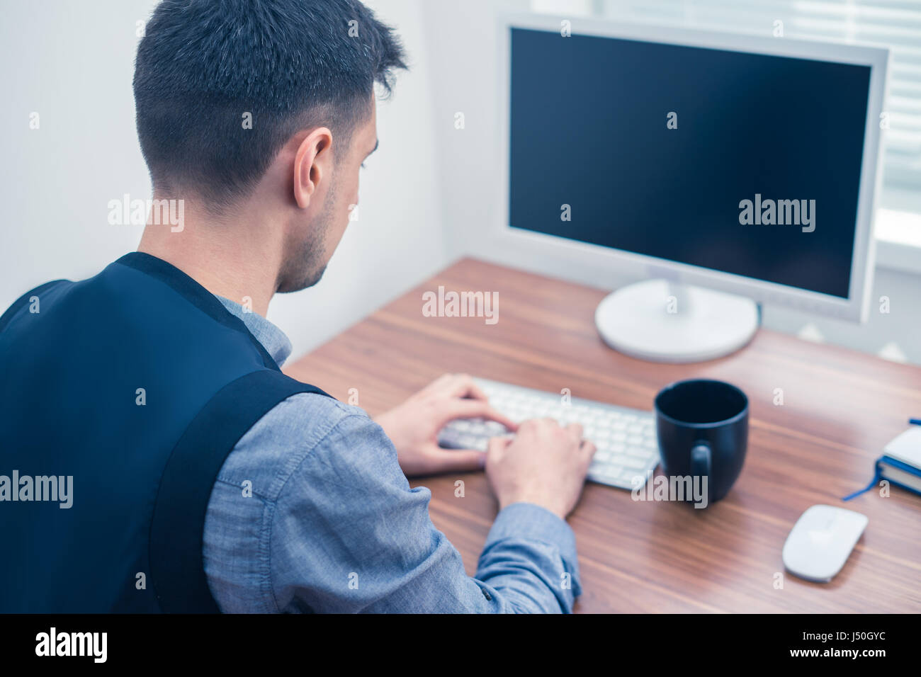 office man typing on keyboard, looking at screen Stock Photo - Alamy