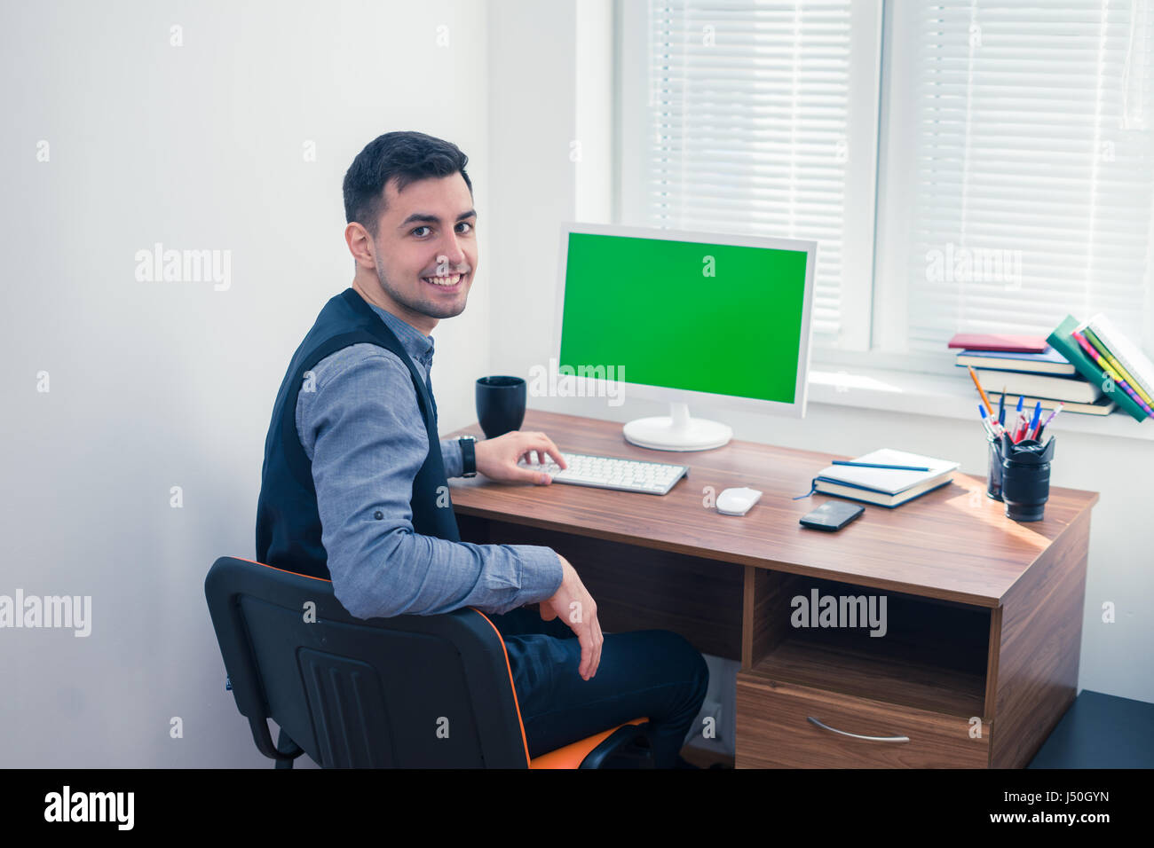 Happy office worker smiling and looking at the camera Stock Photo - Alamy