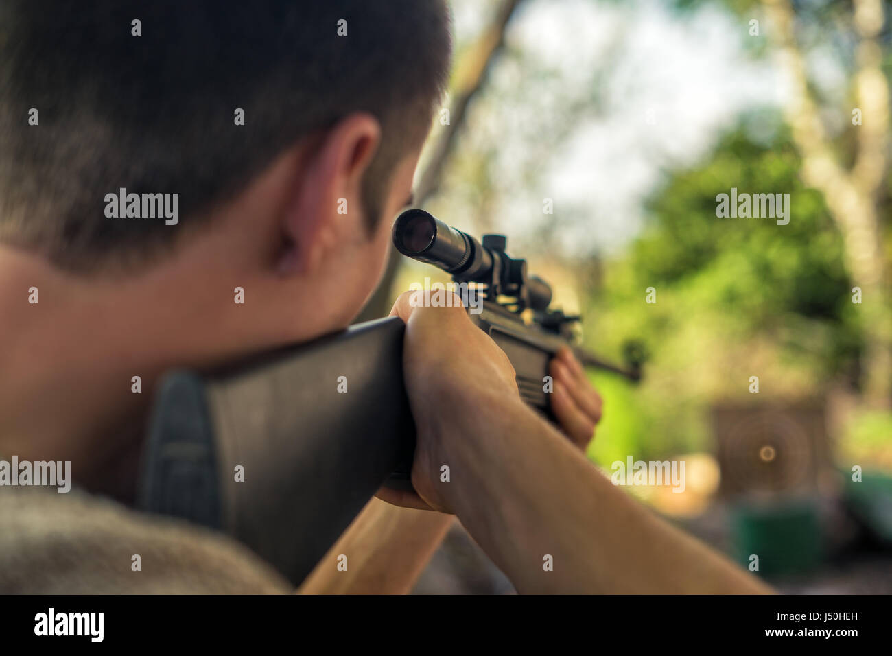 The man takes aim at the target with a sniper rifle. Selective Focus ...