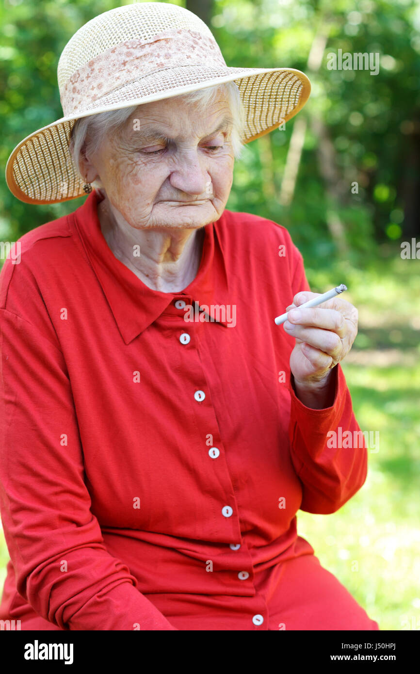 Elderly woman addicted to nicotine and smoking Stock Photo - Alamy