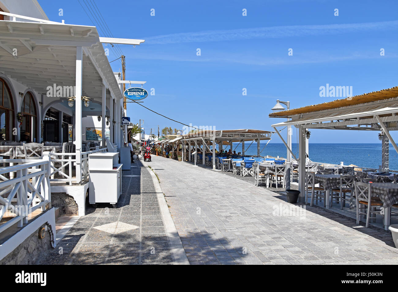 Street view of seafront restaurant hotels in Kamari, Santorini, Greece ...
