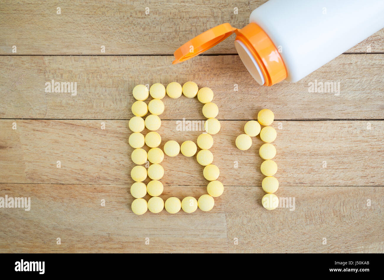 Yellow pills forming shape to B1 alphabet on wood background Stock ...