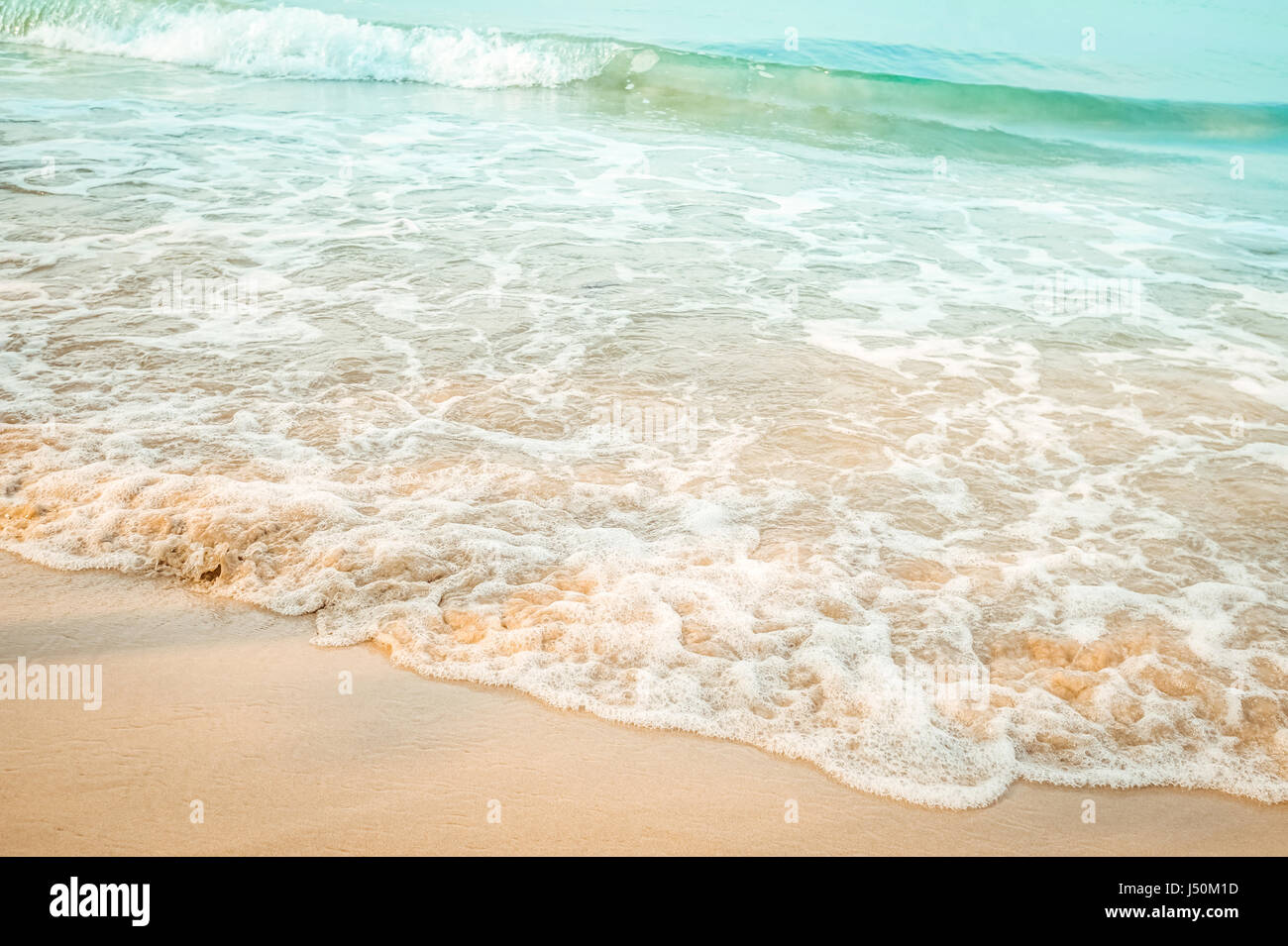 Sea water waves with bubbles on sand beach Stock Photo - Alamy