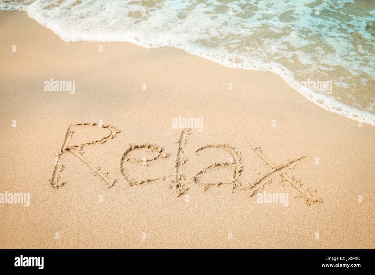 Relax message hand writing on the sand beach Stock Photo - Alamy