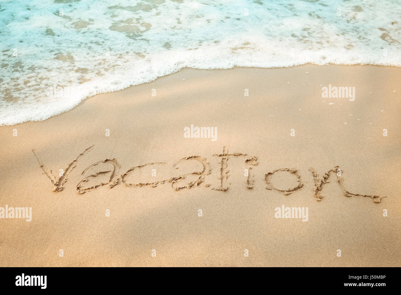 Vacation message hand writing on the sand beach Stock Photo - Alamy