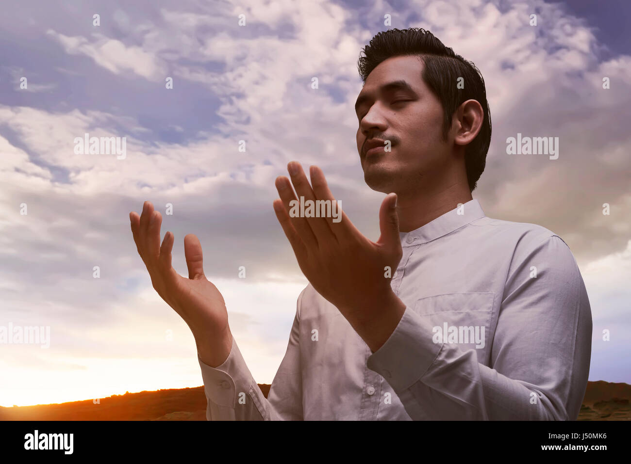 Young asian muslim man praying over sunset background Stock Photo - Alamy