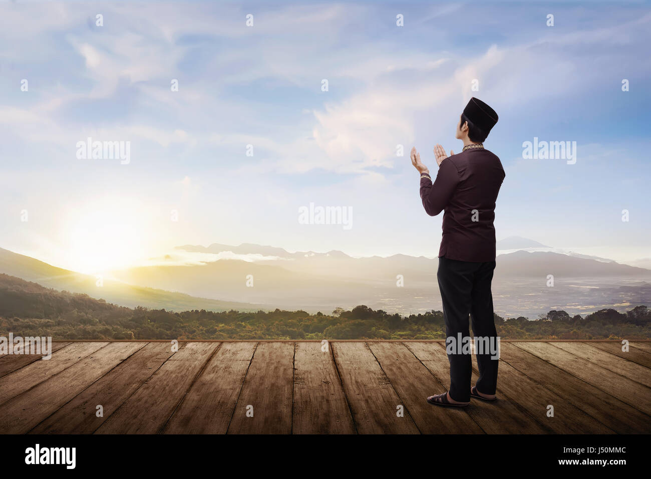 Back view of asian muslim man praying to god with landscape view ...