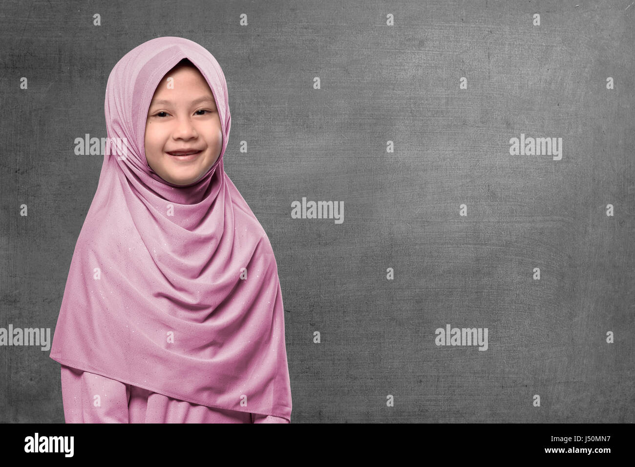 Happy asian muslim kid wearing hijab with smiley face on blackboard ...