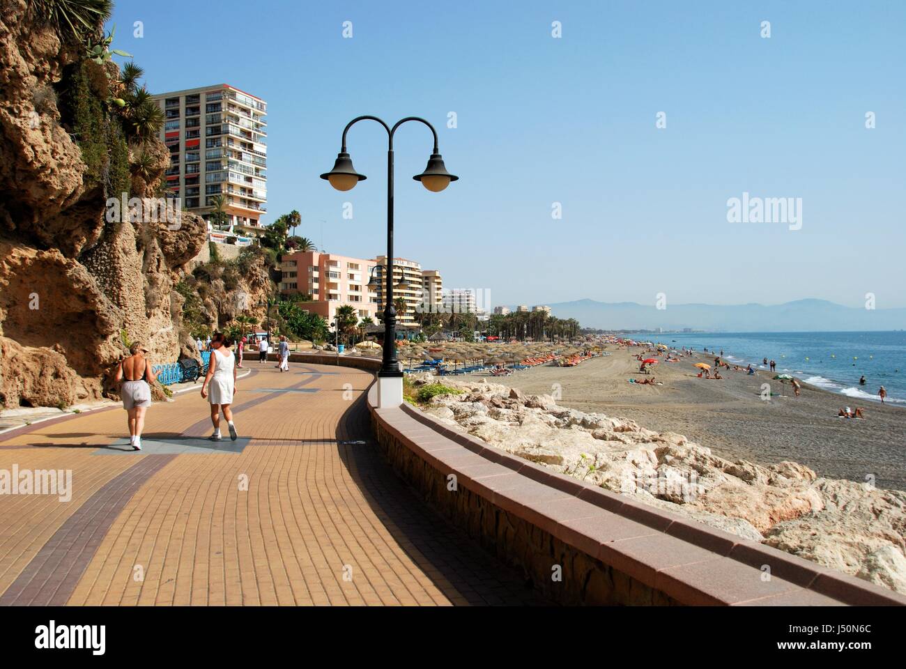 Tourists relaxing on the beach and promenade, Torremolinos, Malaga ...