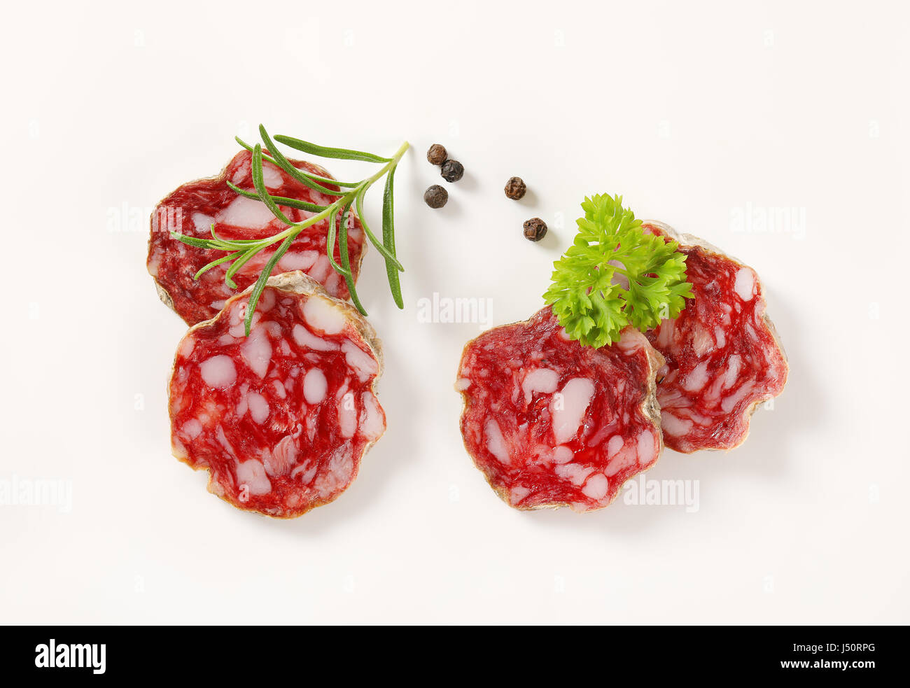 slices of French dry cured salami with spices on white background Stock ...