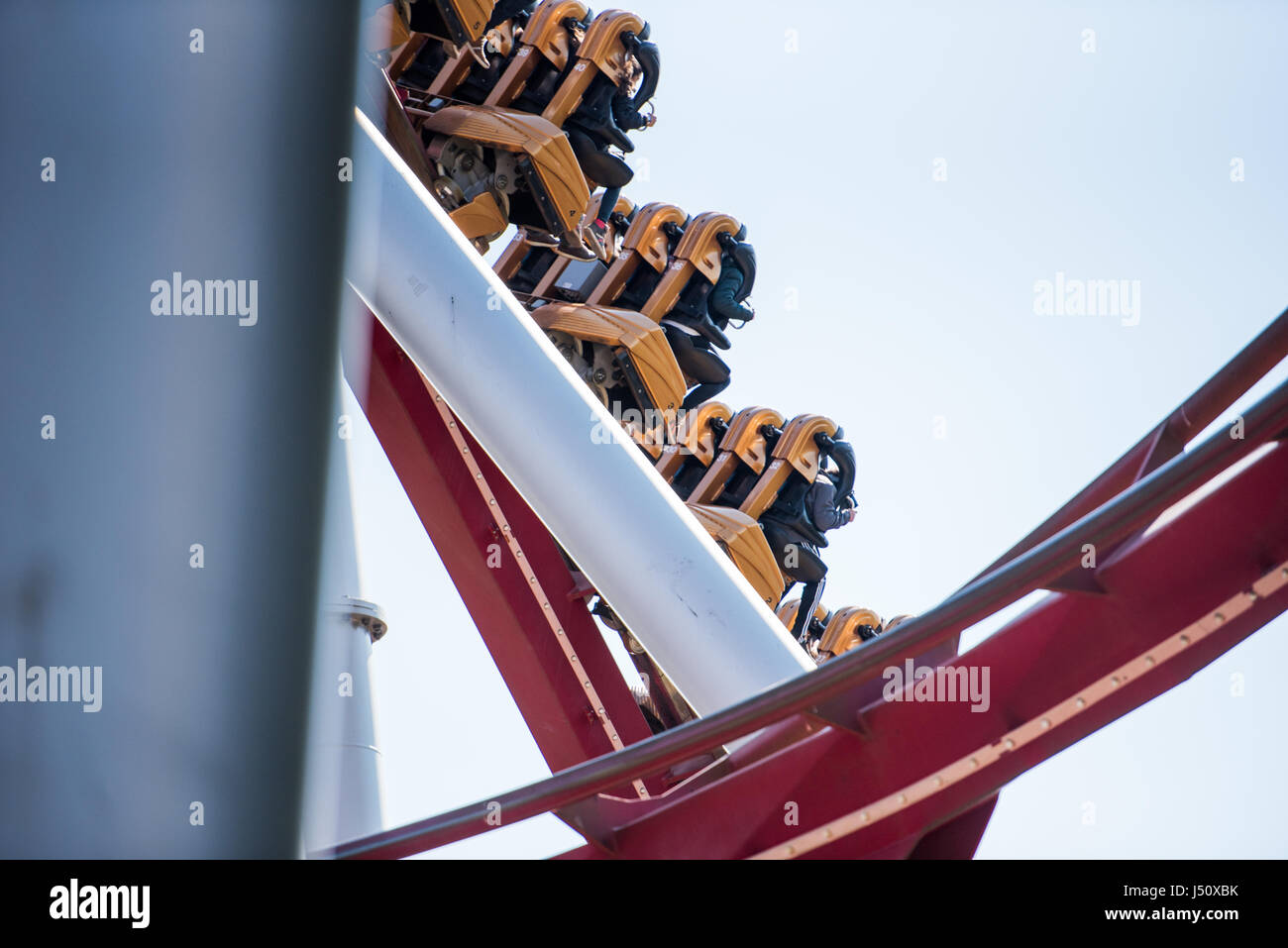 Enthusiastic young friends riding roller coaster ride at amusement park ...