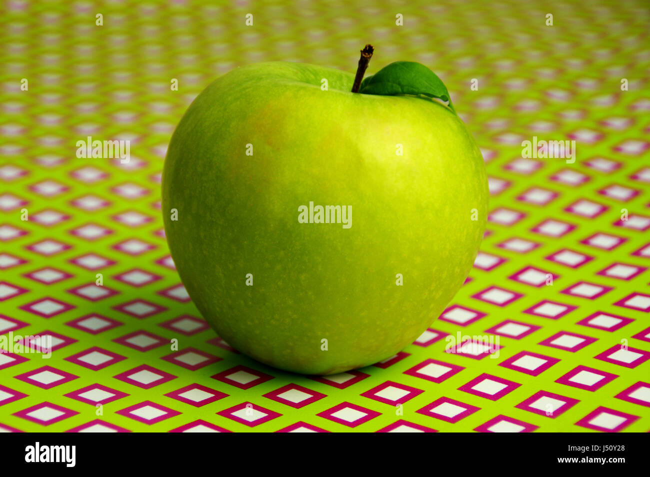 Monochrome apple on regular geometric green background Stock Photo - Alamy