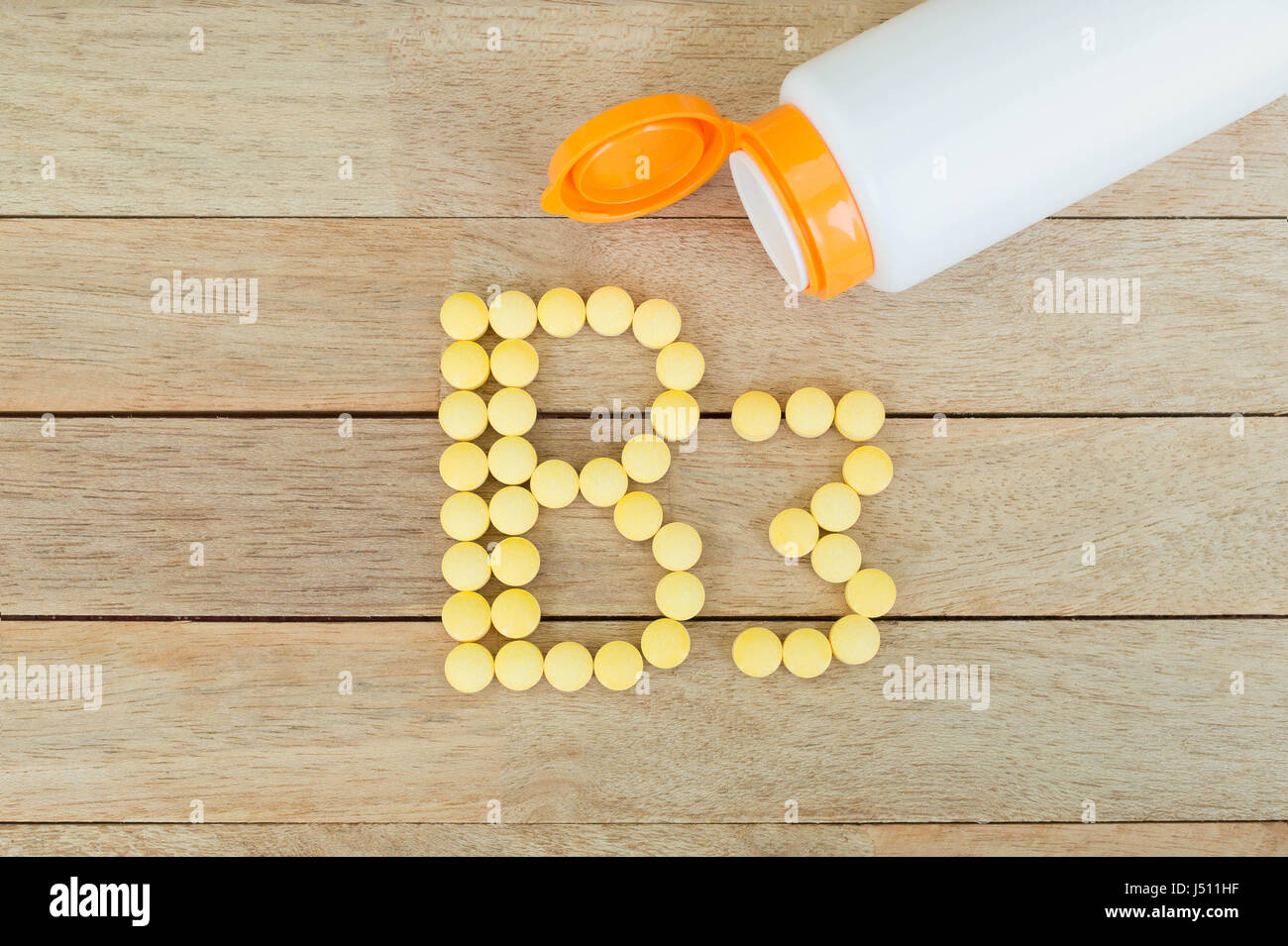 Yellow pills forming shape to B3 alphabet on wood background Stock ...