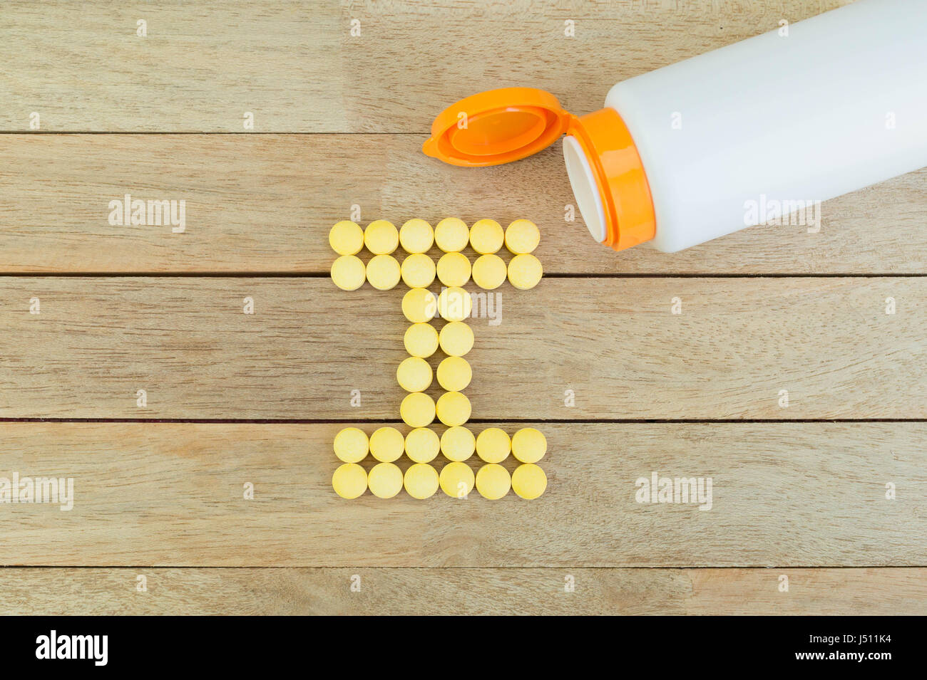 Yellow pills forming shape to I alphabet on wood background Stock Photo ...