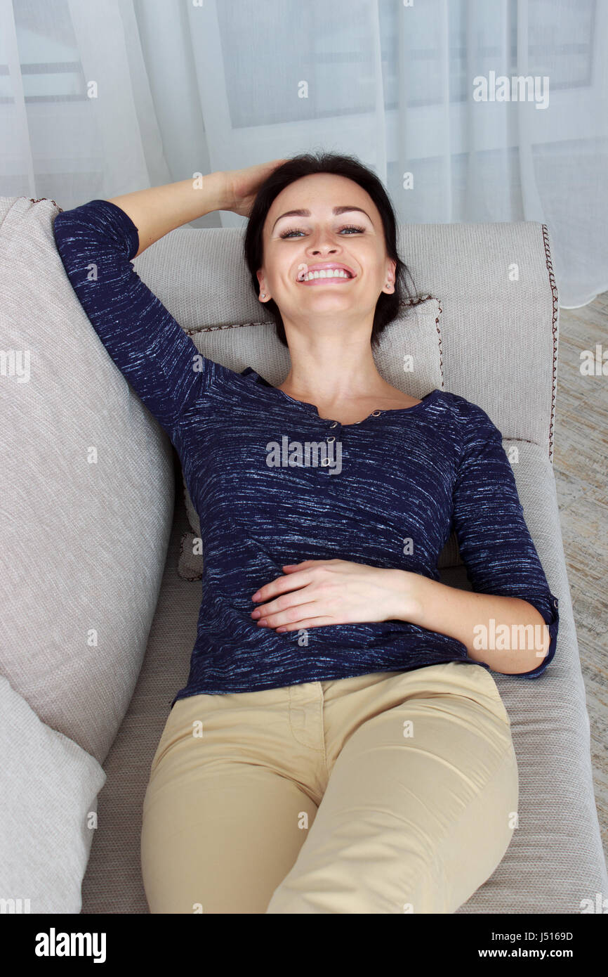 beautiful young woman lying on the couch Stock Photo - Alamy