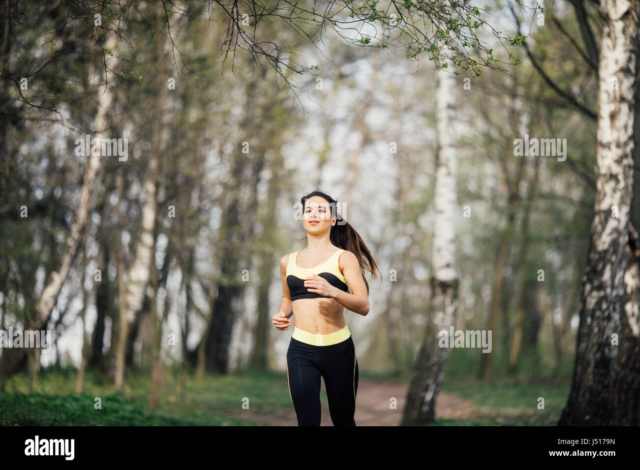 Pretty young girl running in the park Stock Photo - Alamy