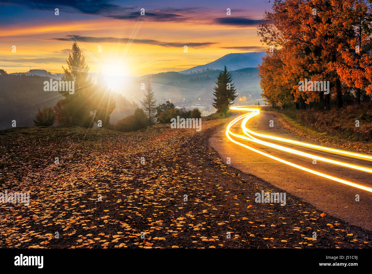 countryside road with car lights. beautiful autumn mountain landscape ...