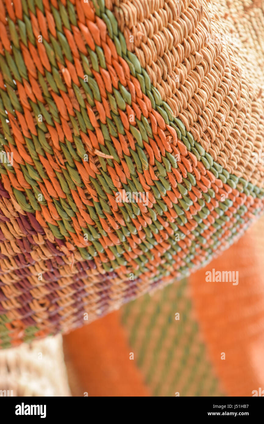 Closeup of a woven straw shopping basket with green, orange, purple ...