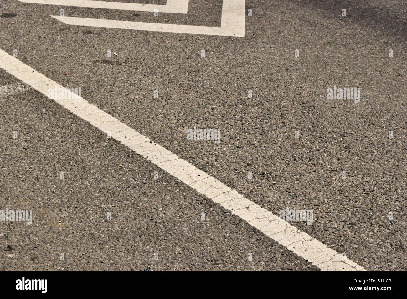 A white diagonal strip across a gray paved road Stock Photo - Alamy