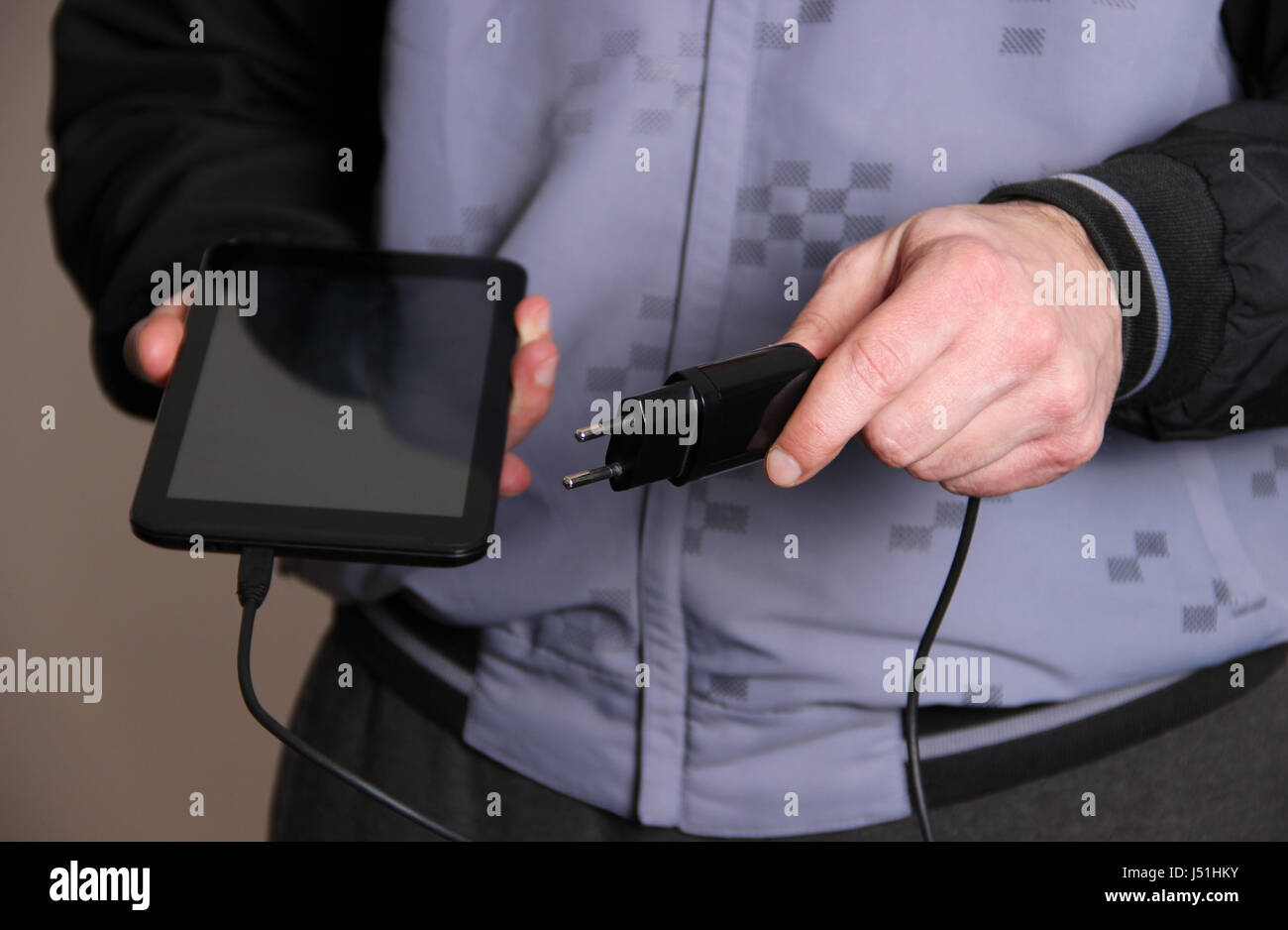 Man charging tablet Stock Photo - Alamy