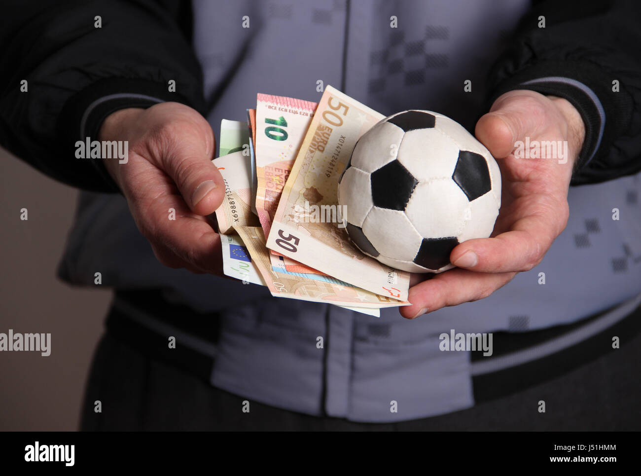 Soccer ball and money in hand Stock Photo - Alamy