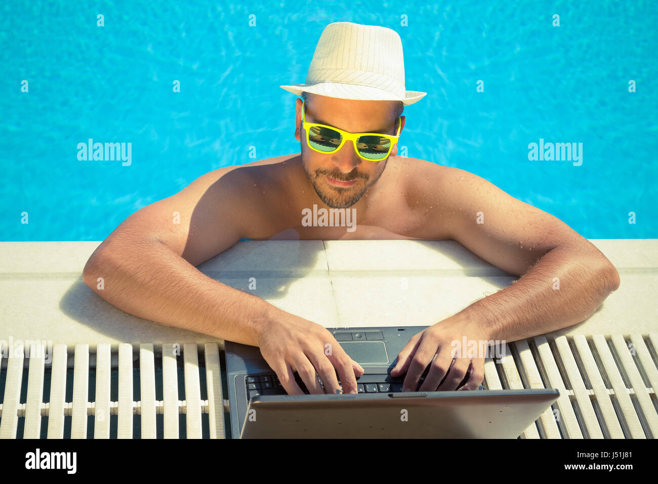 Working on laptop from the swimming pool Stock Photo - Alamy